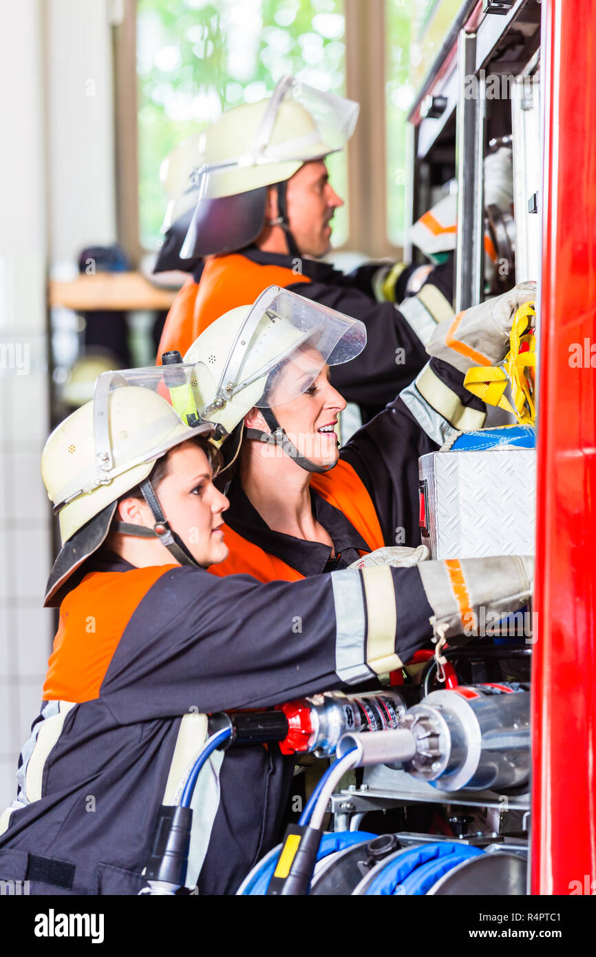 Fire fighters attaching hose at hose laying vehicle Stock Photo - Alamy
