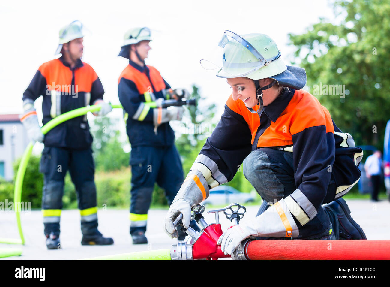 Fire fighter connecting hoses Stock Photo - Alamy