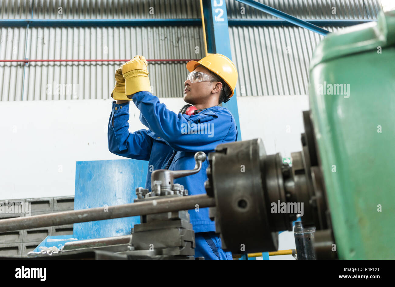 Worker checking quality behind an industrial machine Stock Photo - Alamy