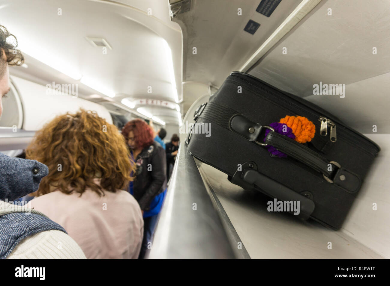 Close up of overhead bin space on a crowded airplane Stock Photo - Alamy