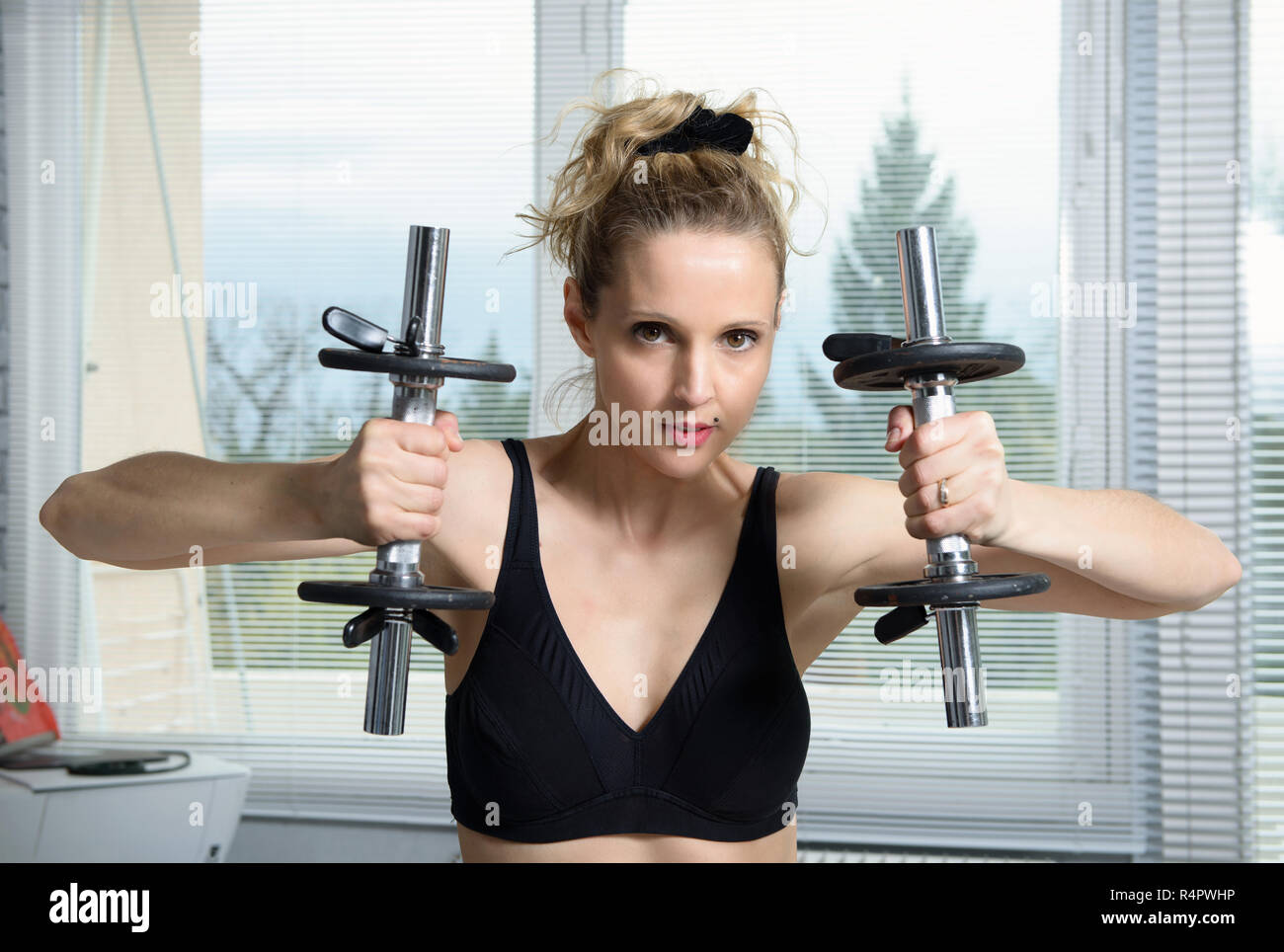 pretty fitness woman lifting dumbbells Stock Photo - Alamy