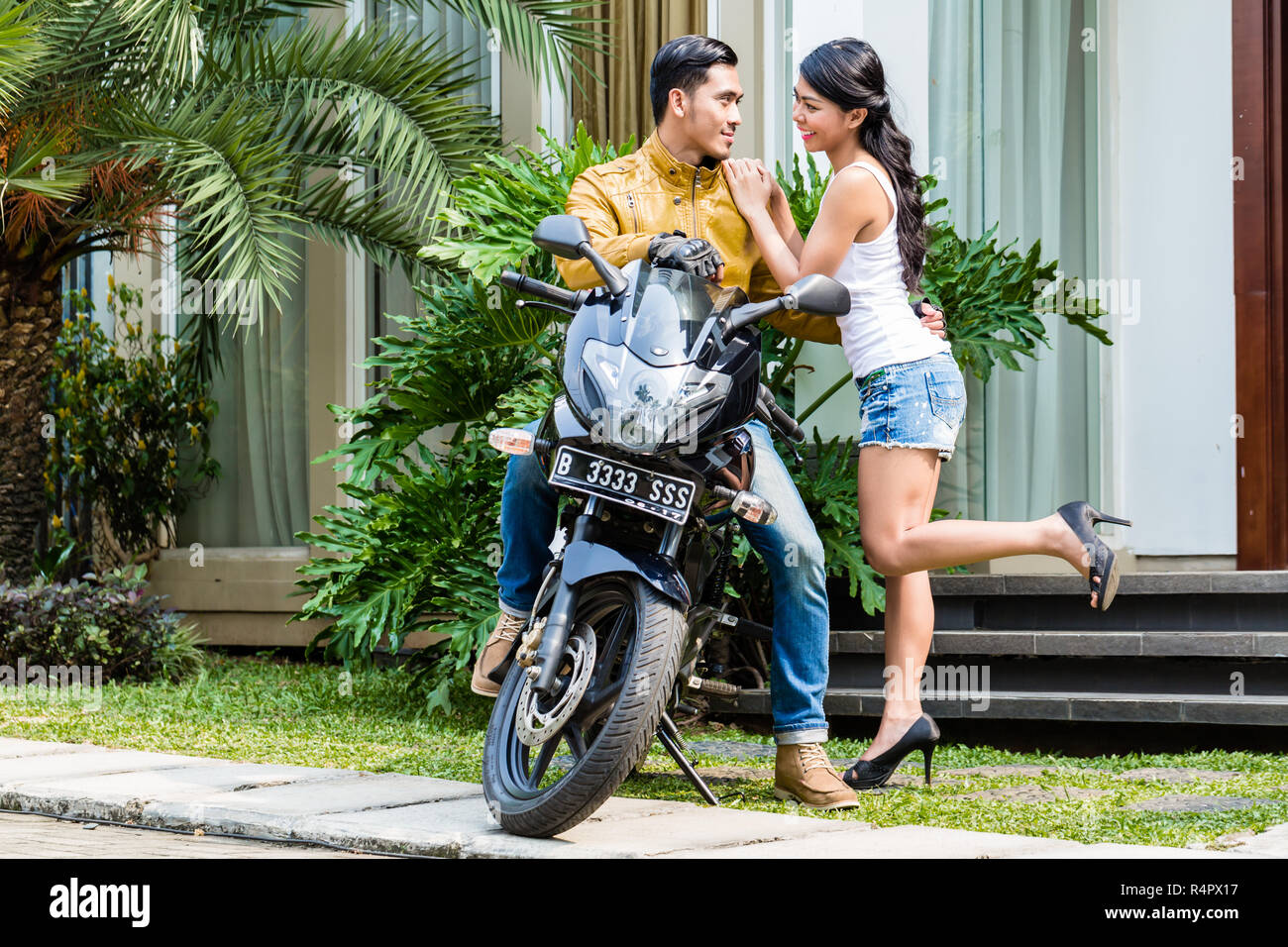 Woman saying goodbye to motorcyclist Stock Photo - Alamy