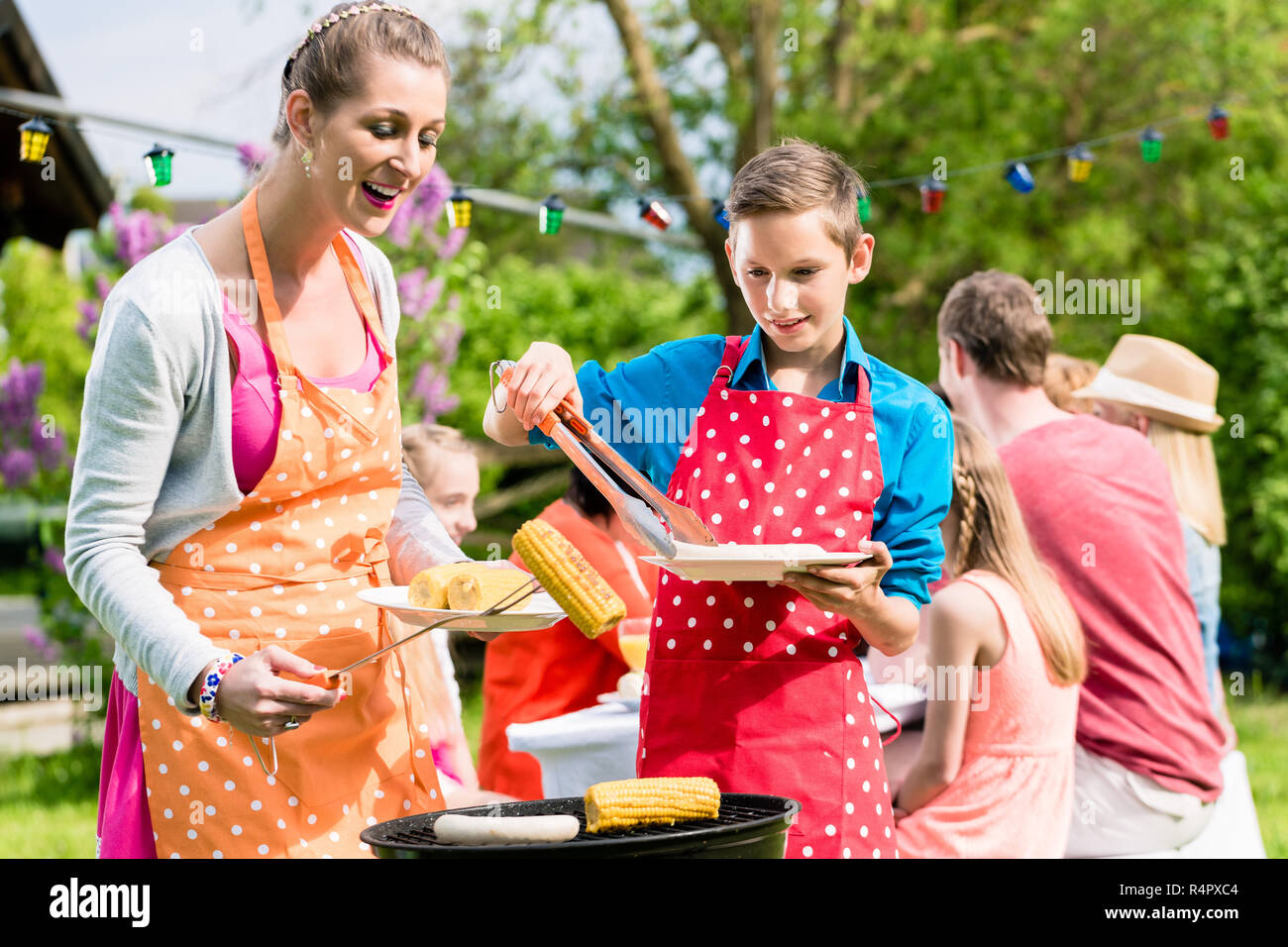 Mother and son grilling meat at garden barbeque Stock Photo - Alamy