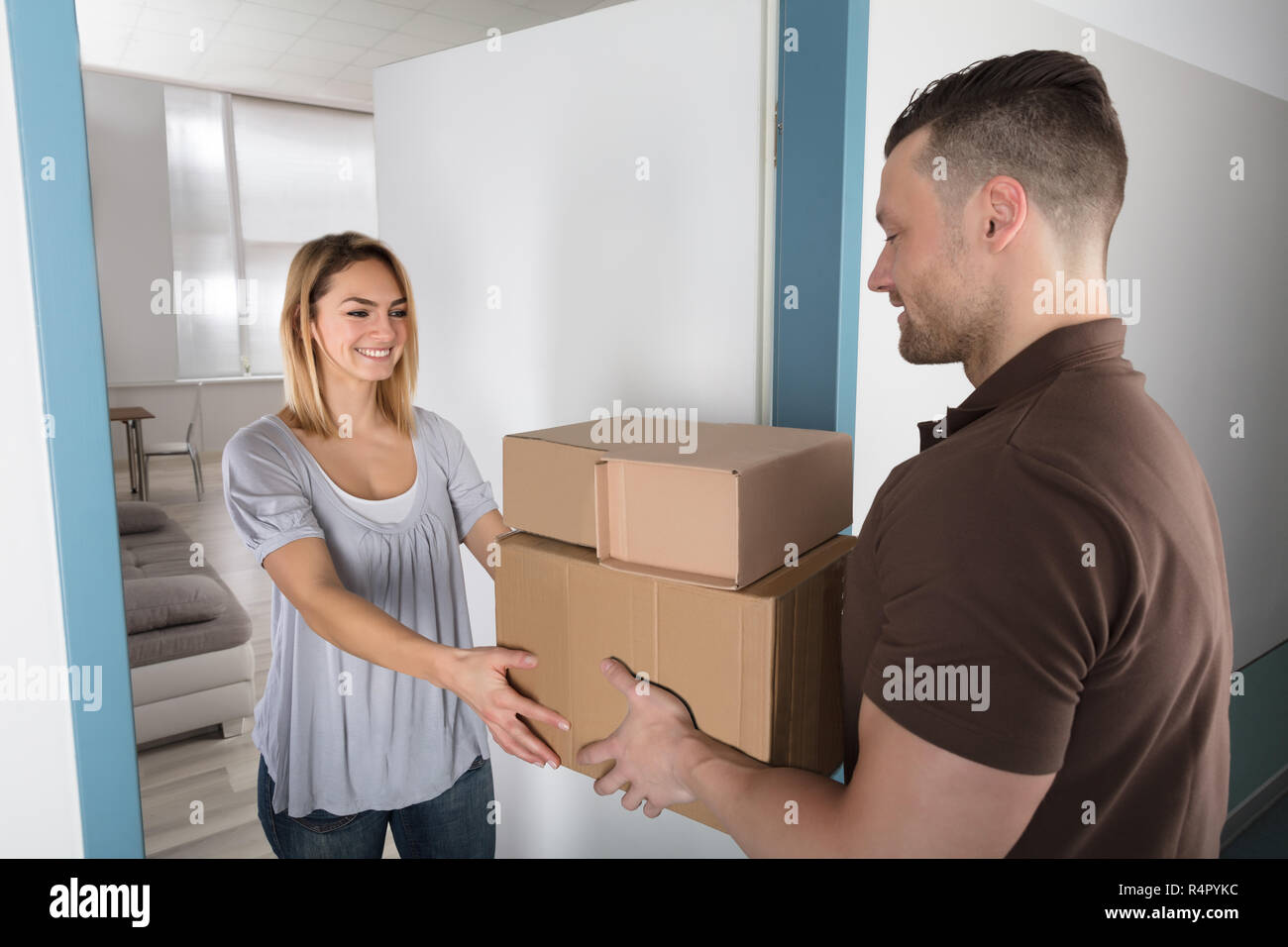 Delivery Man Giving Parcel Box To Young Woman Stock Photo - Alamy