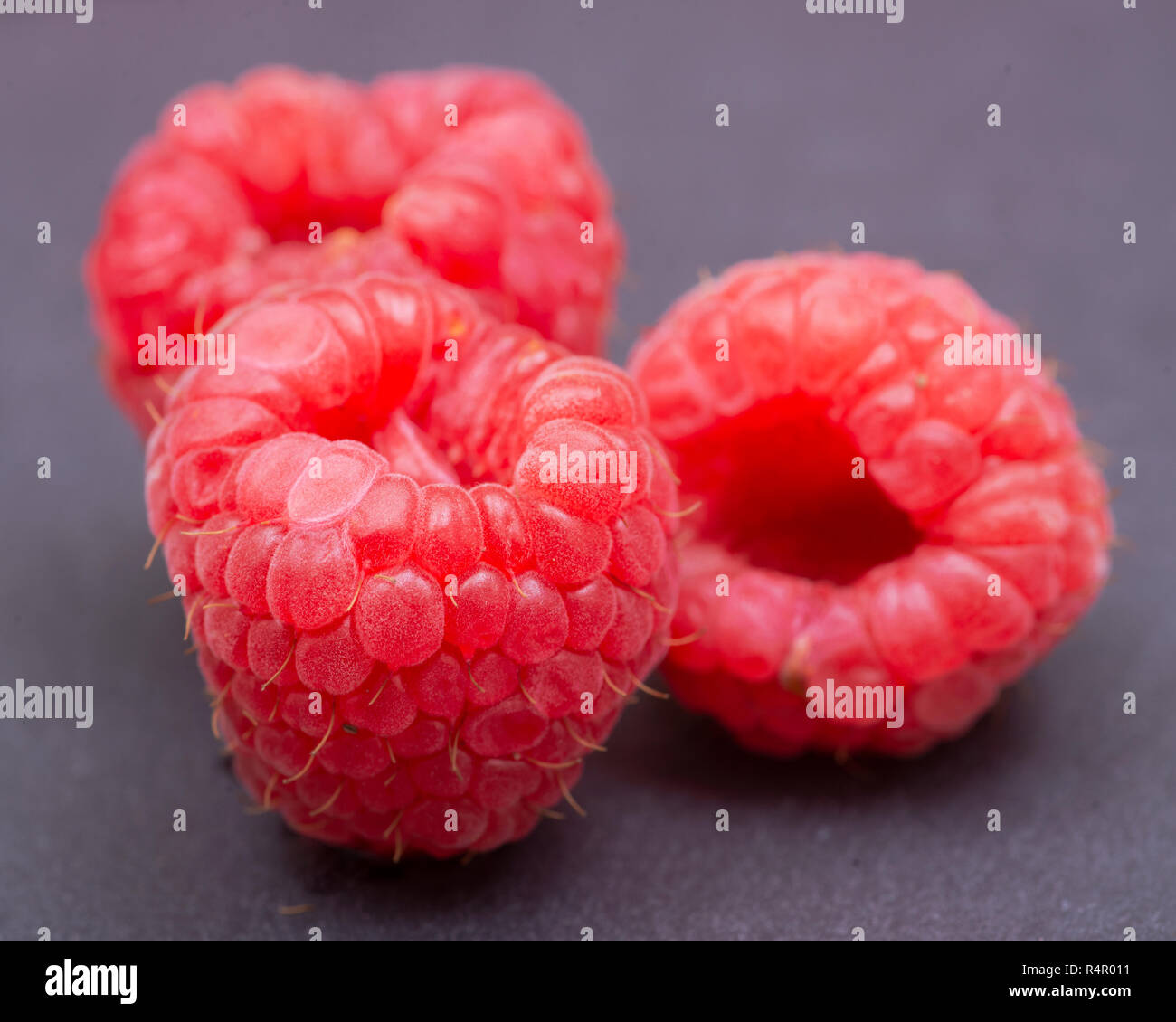 Macro shot of ripe organic raspberries on natural stone background ...