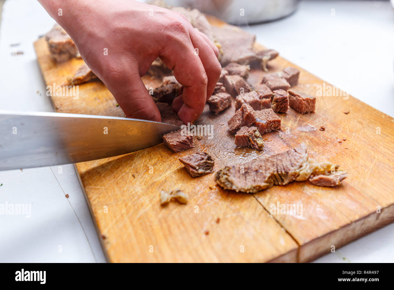The cook cuts boiled beef meat Stock Photo - Alamy