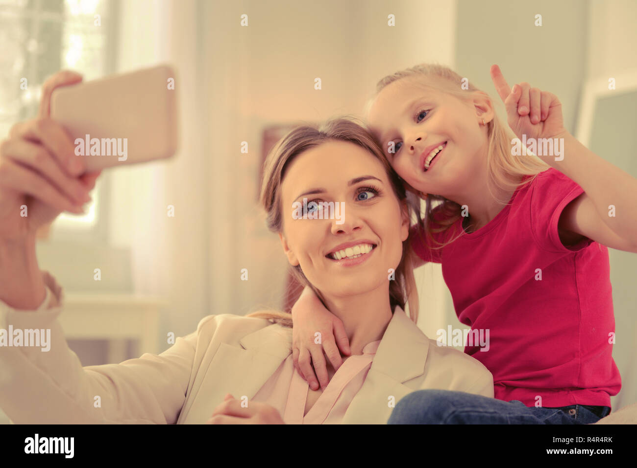 Happy positive mom and daughter taking selfies together Stock Photo - Alamy