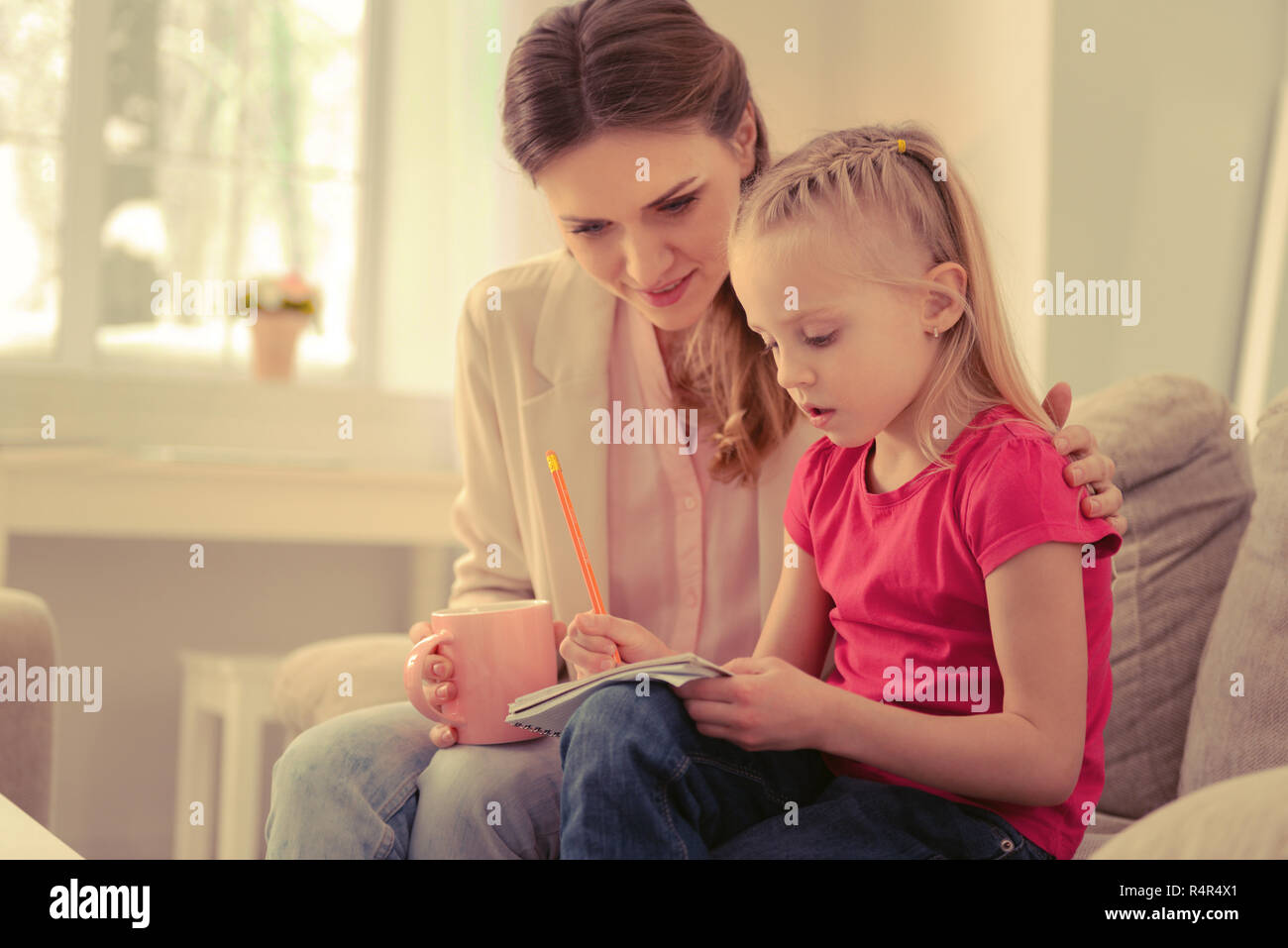 Nice cute girl drawing a picture in her notebook Stock Photo - Alamy