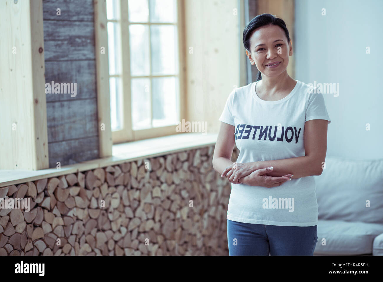 Positive delighted young female person welcoming guests Stock Photo - Alamy