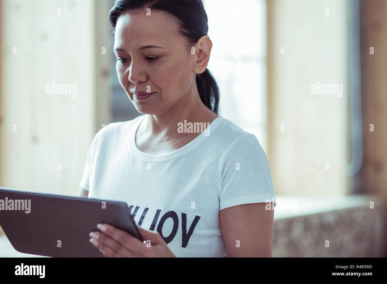 Serious Asian woman typing message to her colleague Stock Photo - Alamy