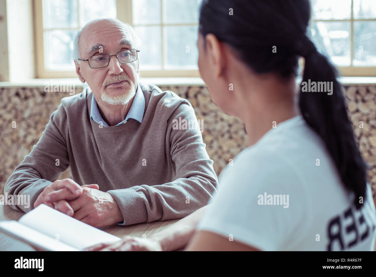 Serious mature man looking at his social worker Stock Photo - Alamy