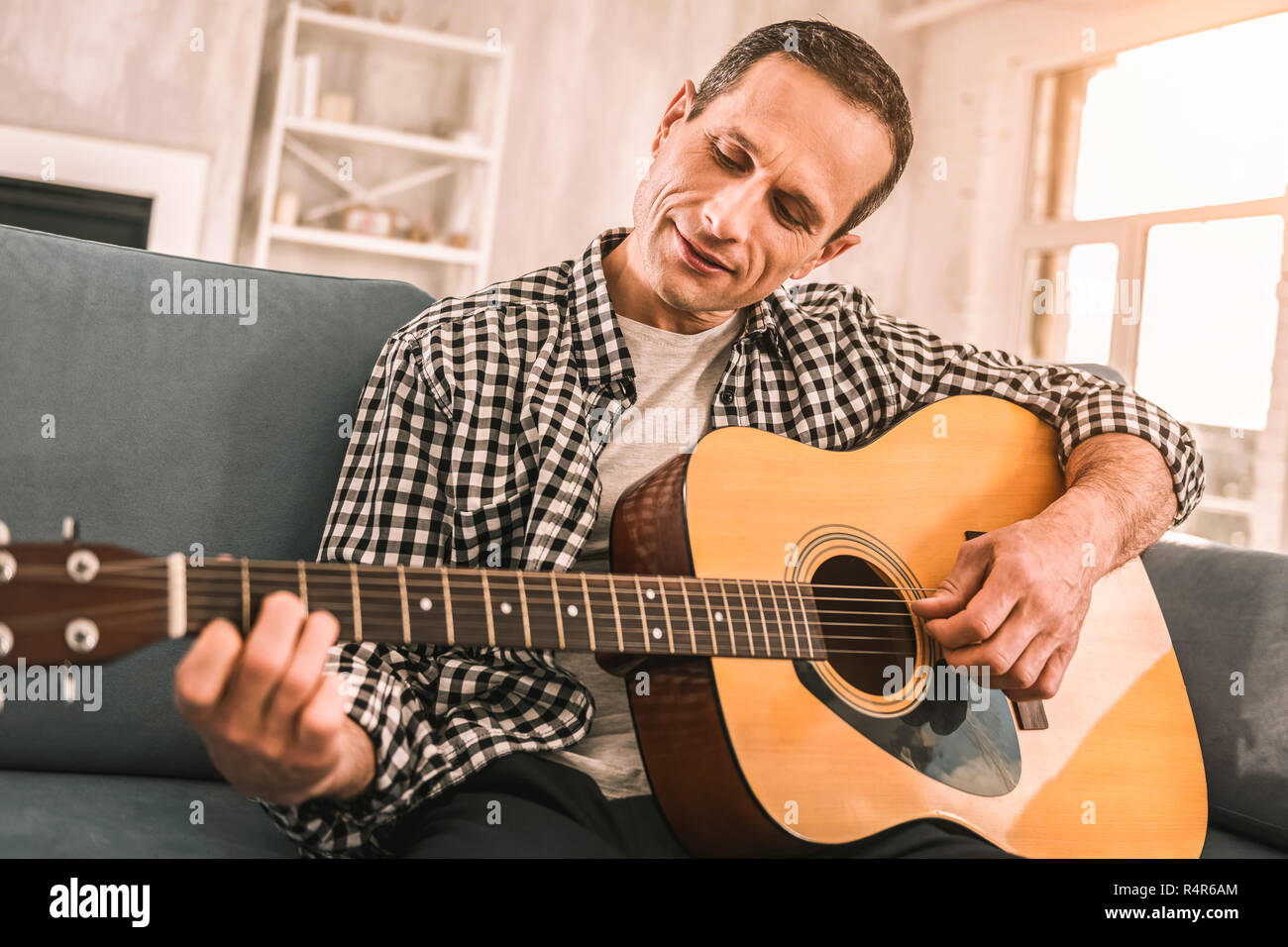 Focused inspired man playing his favourite instrument Stock Photo - Alamy