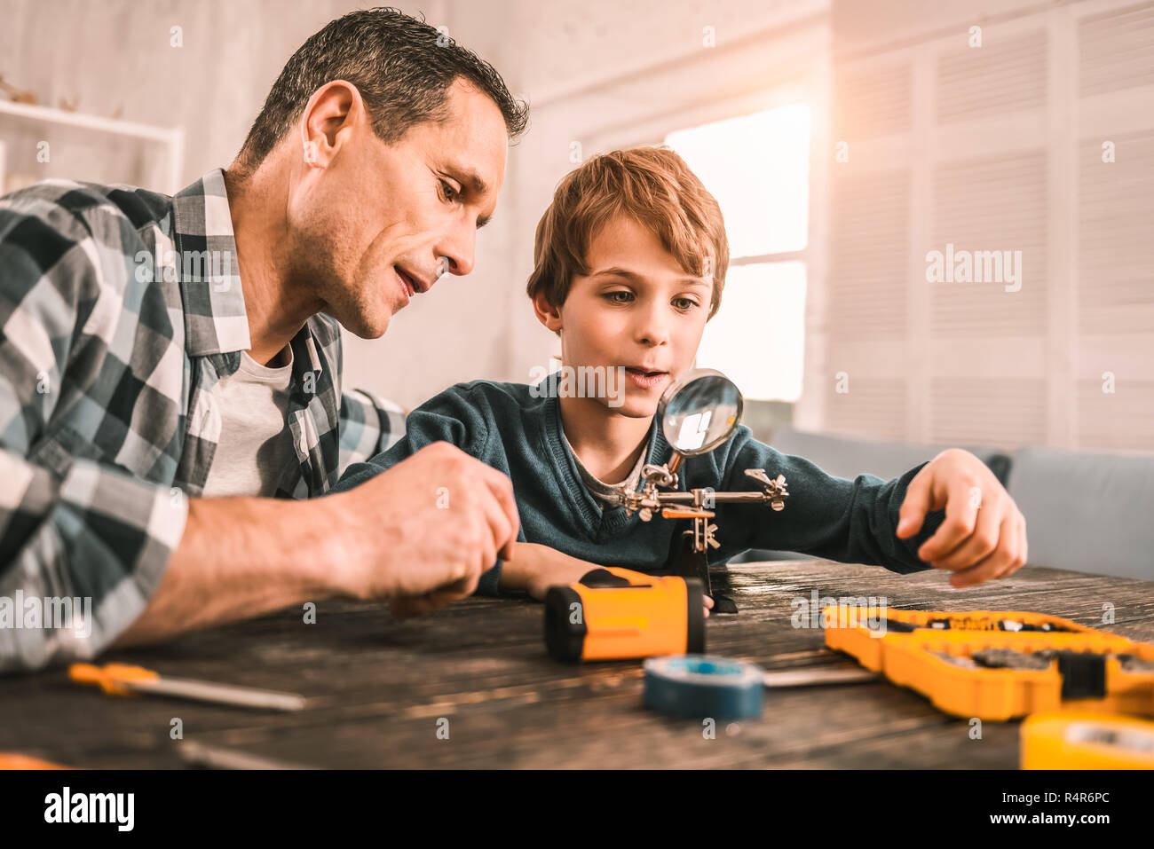 Father and son observing small things through the looking glass Stock ...