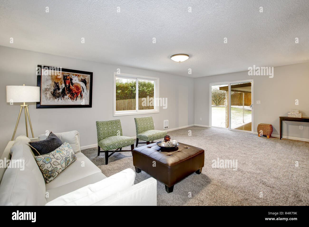 Light spacious living area with couch , two chairs and ottoman Stock ...