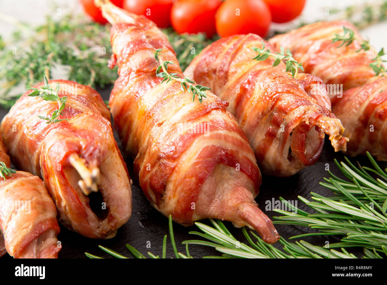 baked quail wrapped in bacon on a slate board with spices Stock Photo ...