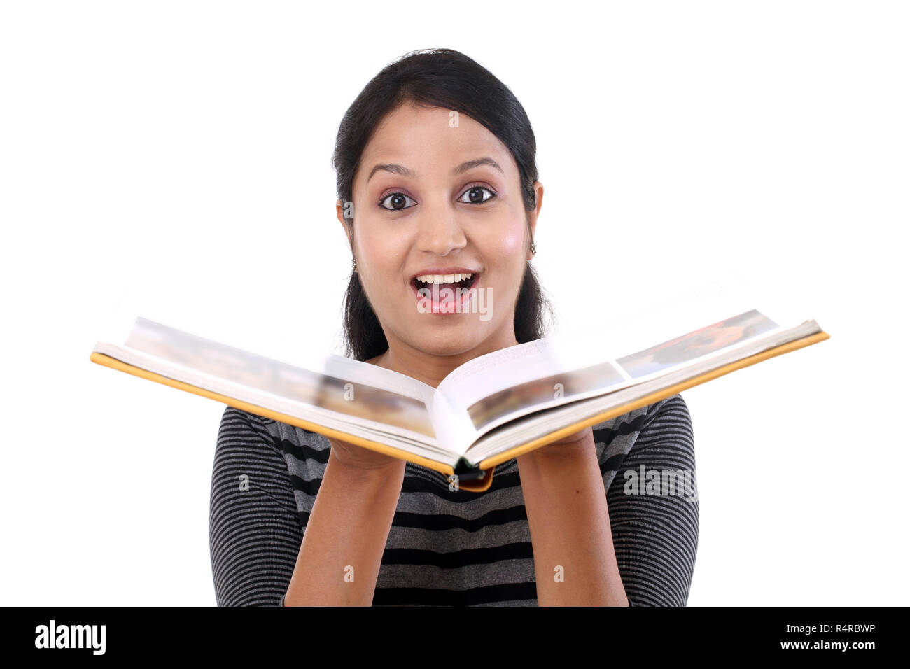 Excited young woman reading a book Stock Photo - Alamy