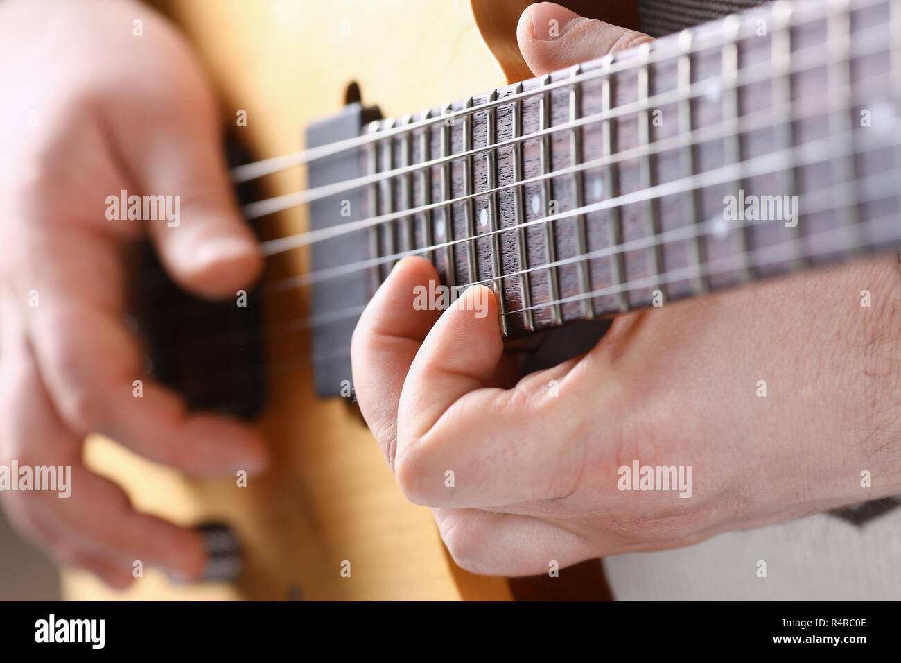 Male arms playing classic shape electric guitar Stock Photo - Alamy