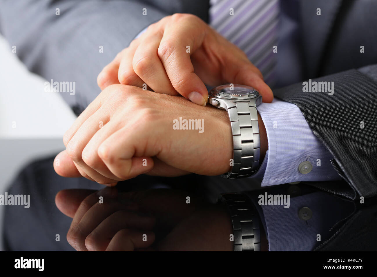 Man in suit and tie check out time at Stock Photo - Alamy