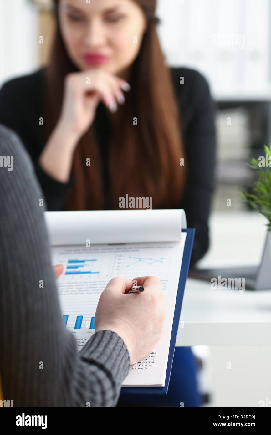 Female arm holding silver pen point in financial graph Stock Photo - Alamy