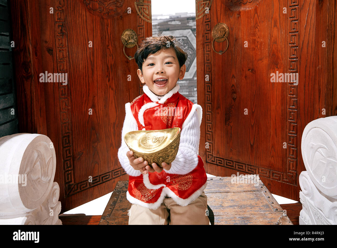 Lovely boy holding gold ingot Stock Photo - Alamy