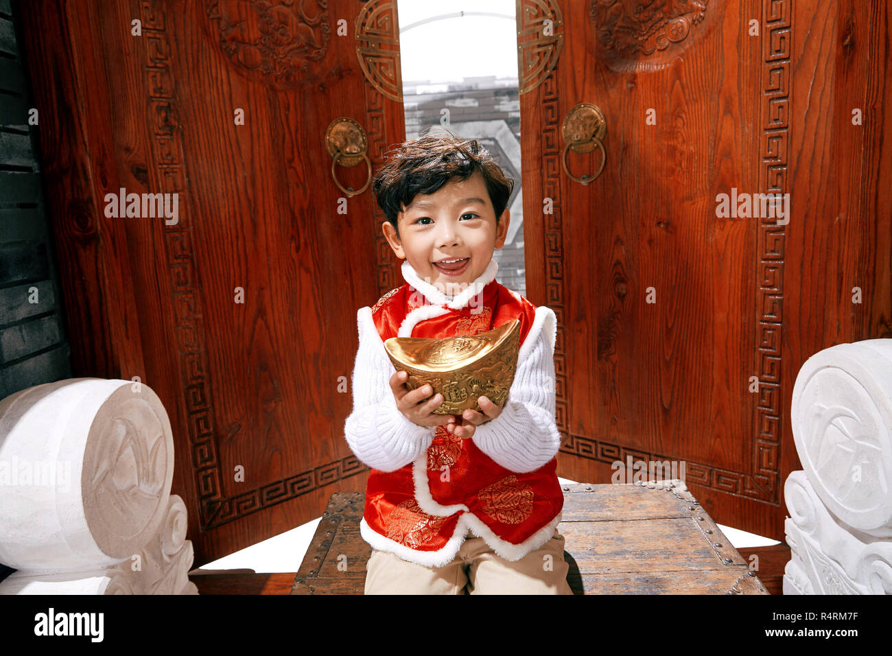 Lovely boy holding gold ingot Stock Photo - Alamy