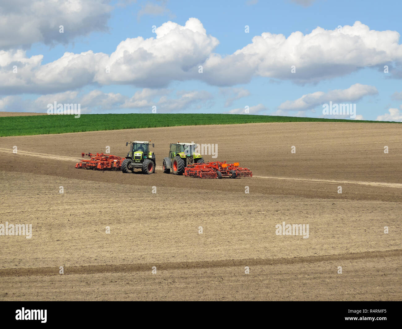 Tractors process the farmlandland Stock Photo - Alamy