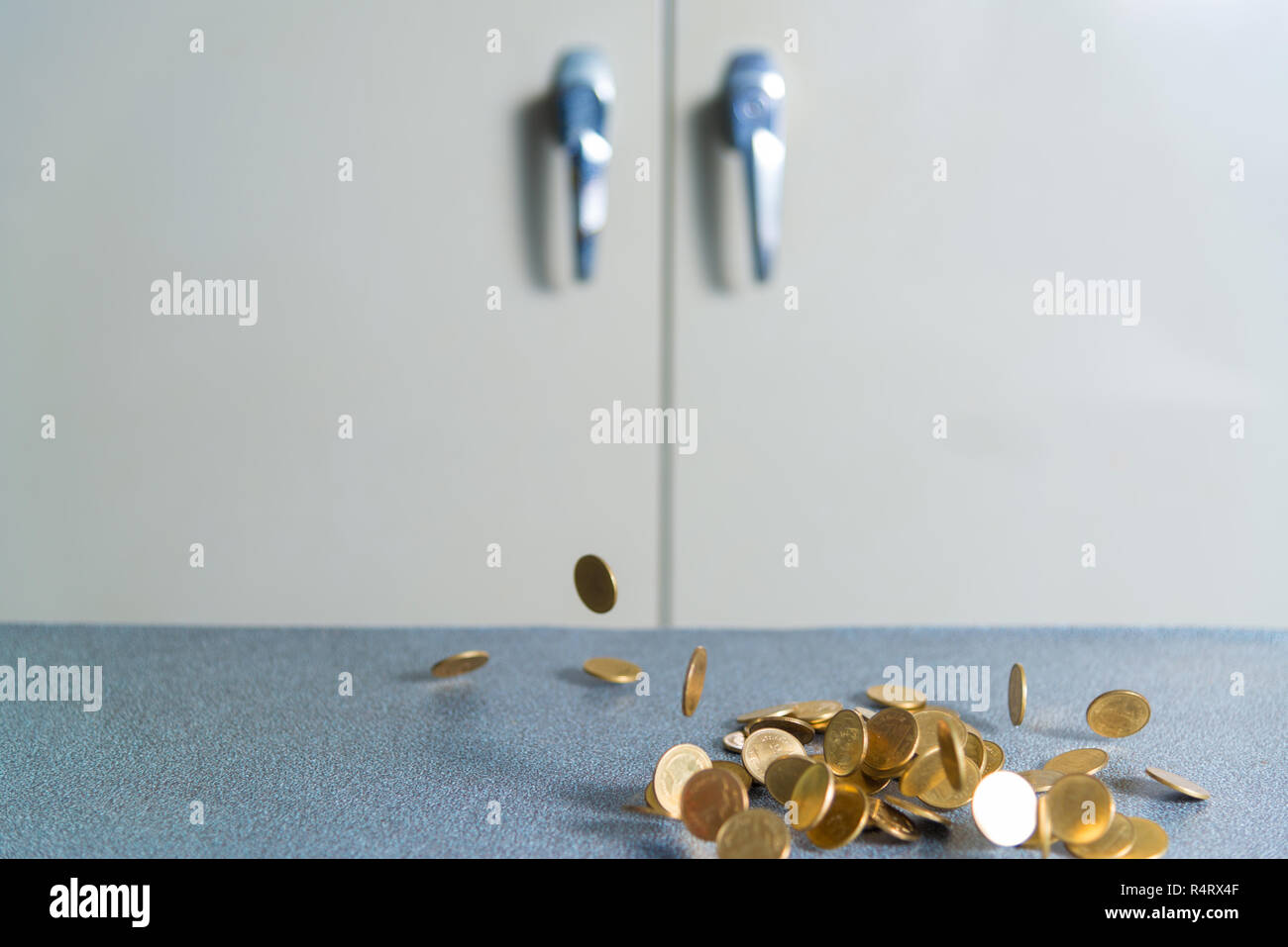 Falling gold coins money on office table with document cabinet ...