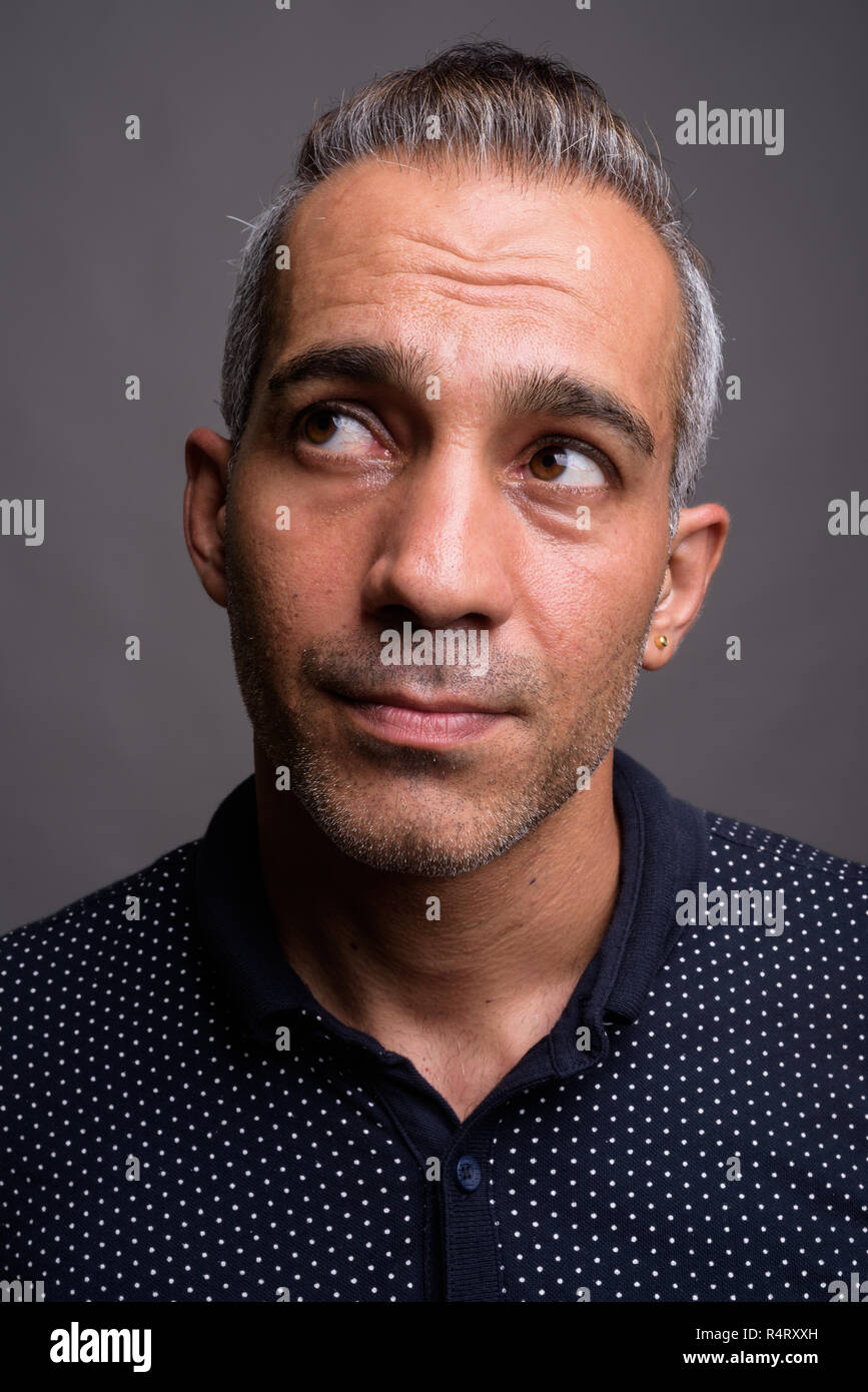 Face of handsome Persian man thinking and looking up Stock Photo - Alamy
