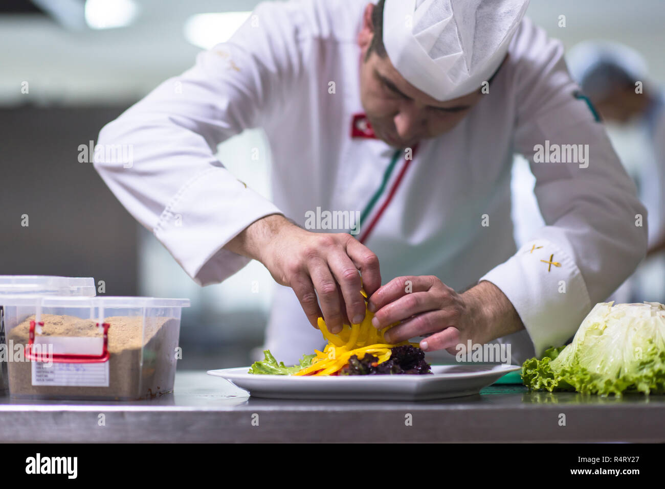 chef serving vegetable salad on plate in restaurant kitchen Stock Photo ...