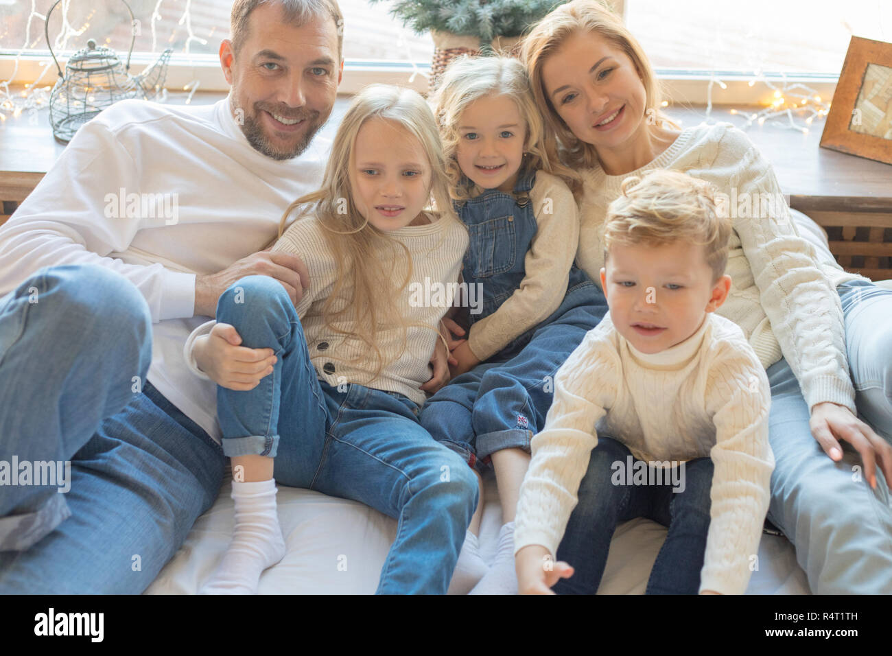Friendly family of five people sitting on the bed Stock Photo - Alamy