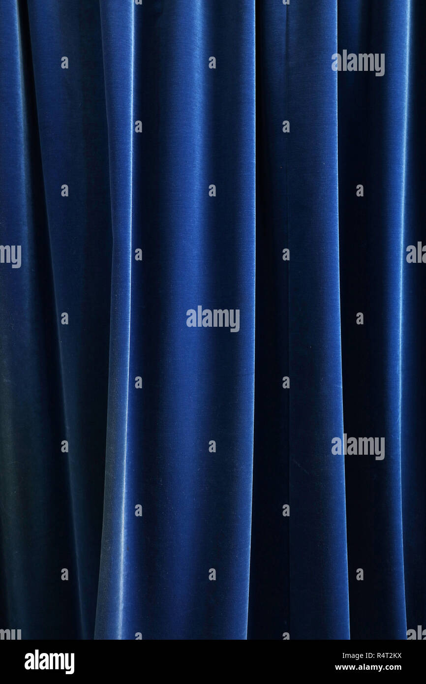 Heavy dark blue pleated textile curtain background Stock Photo - Alamy