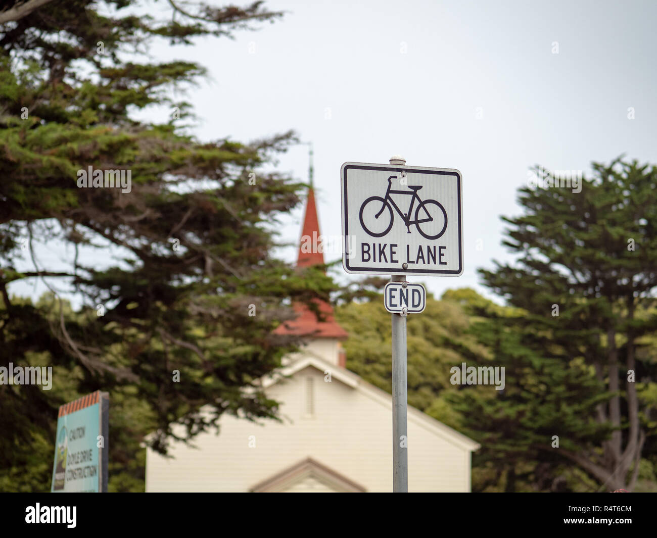 Bike lane end sign handing in front of a church outdoors Stock Photo ...