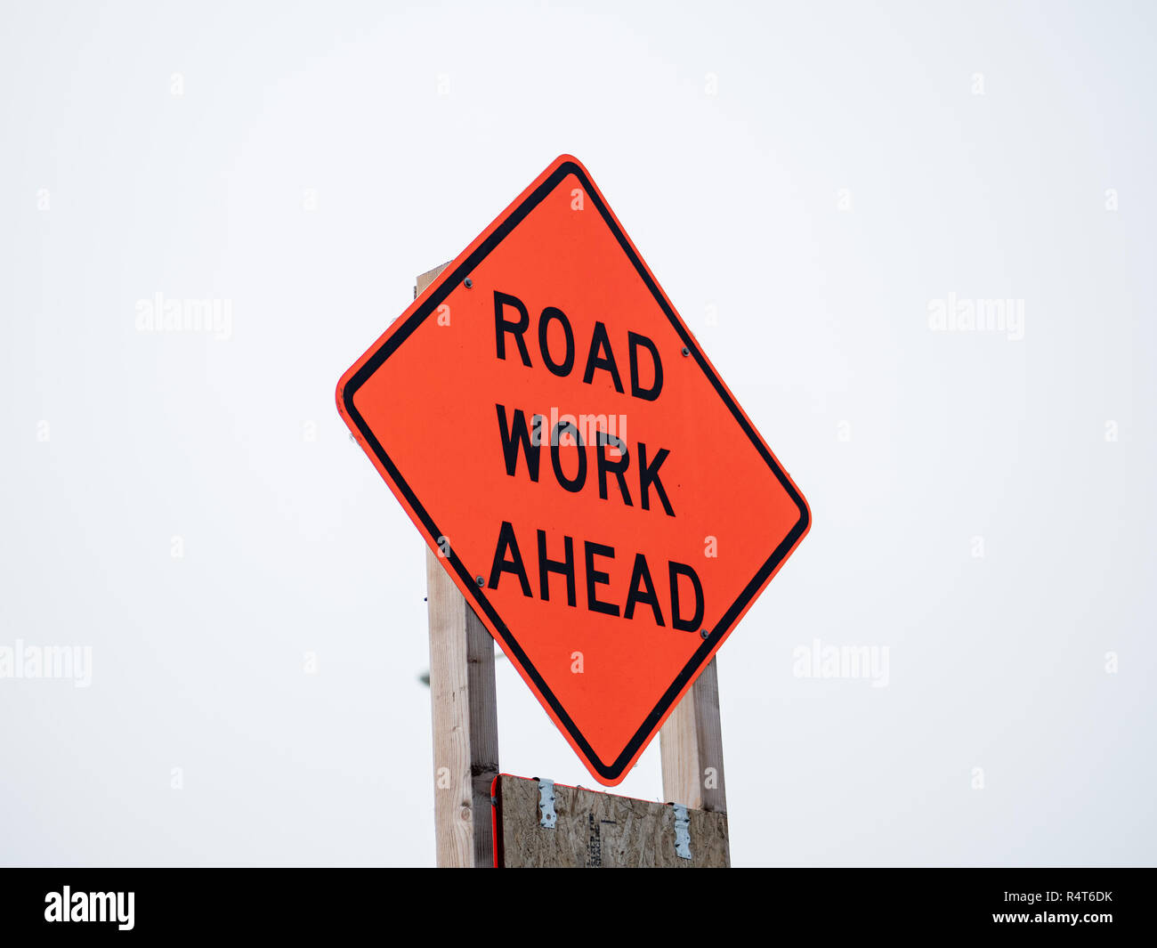 Road work ahead orange sign posted on wooden post on overcast sky Stock ...