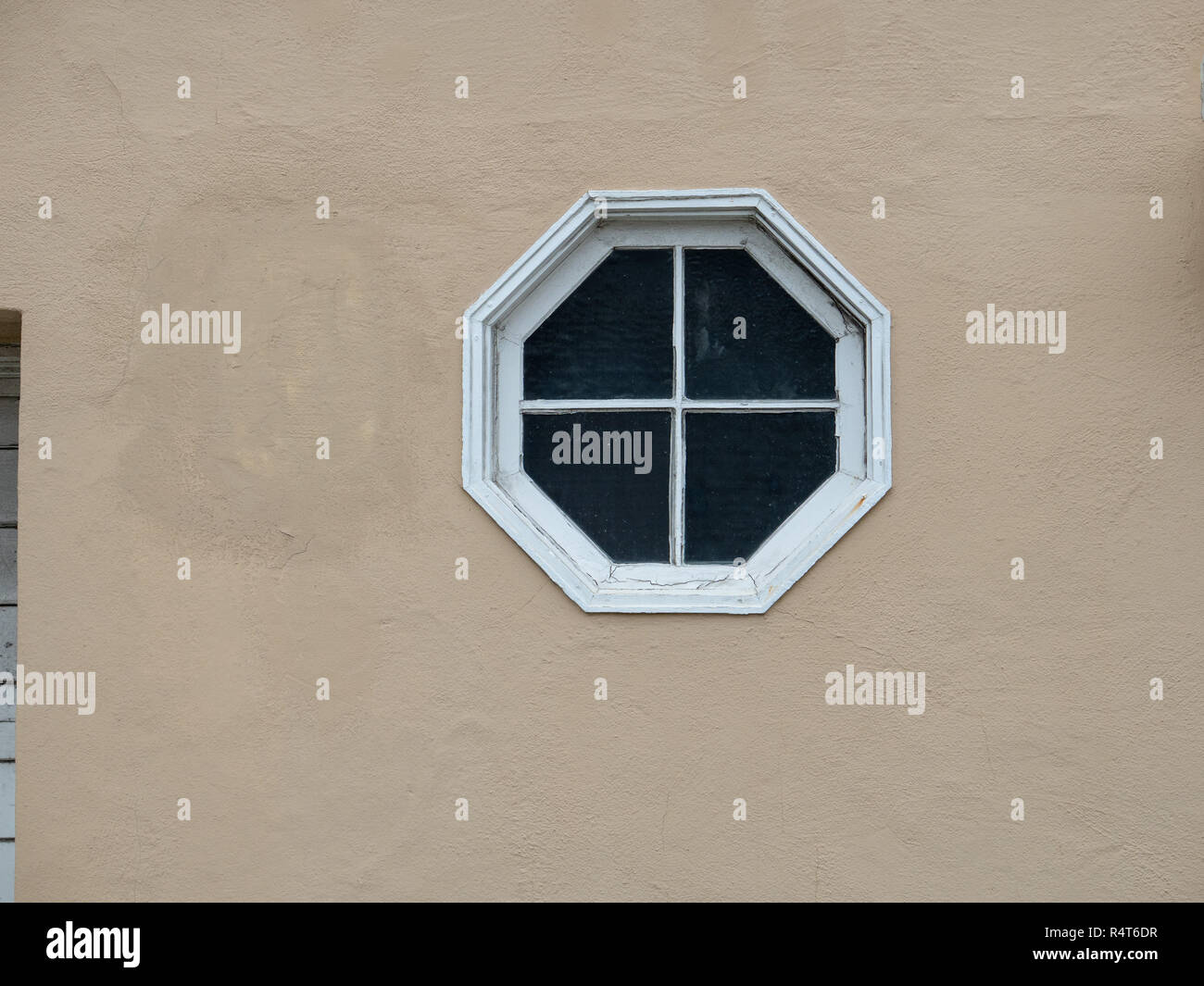 Octagon shaped glass window on the side of beige house Stock Photo - Alamy