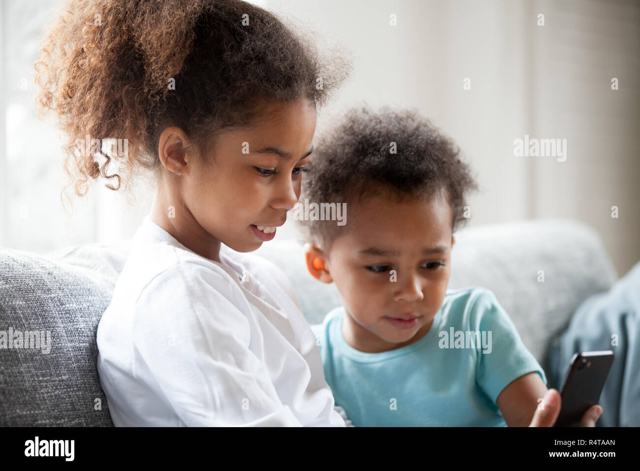 Children watching mobile phone screen hi-res stock photography and ...