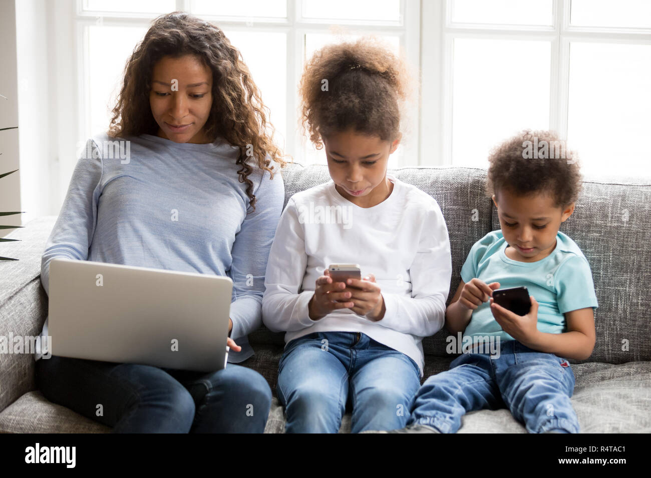 African American family using devices, ignoring each other Stock Photo ...