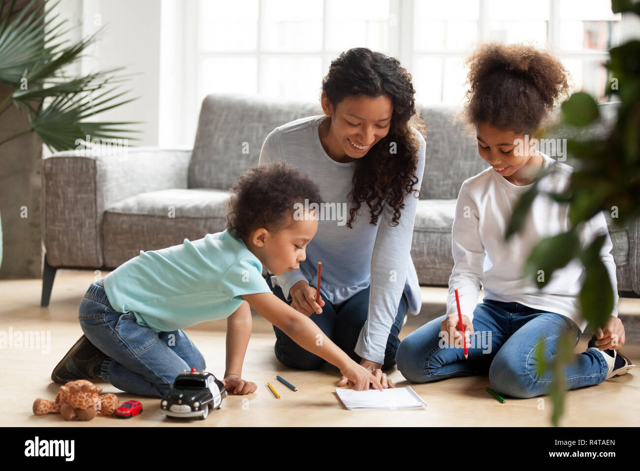 Happy African American mother drawing with children Stock Photo - Alamy