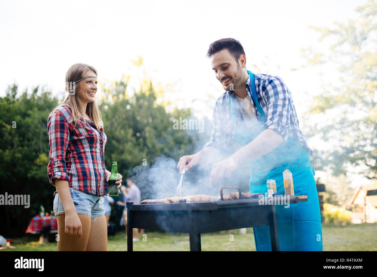 Happy friends enjoying barbecue party Stock Photo - Alamy