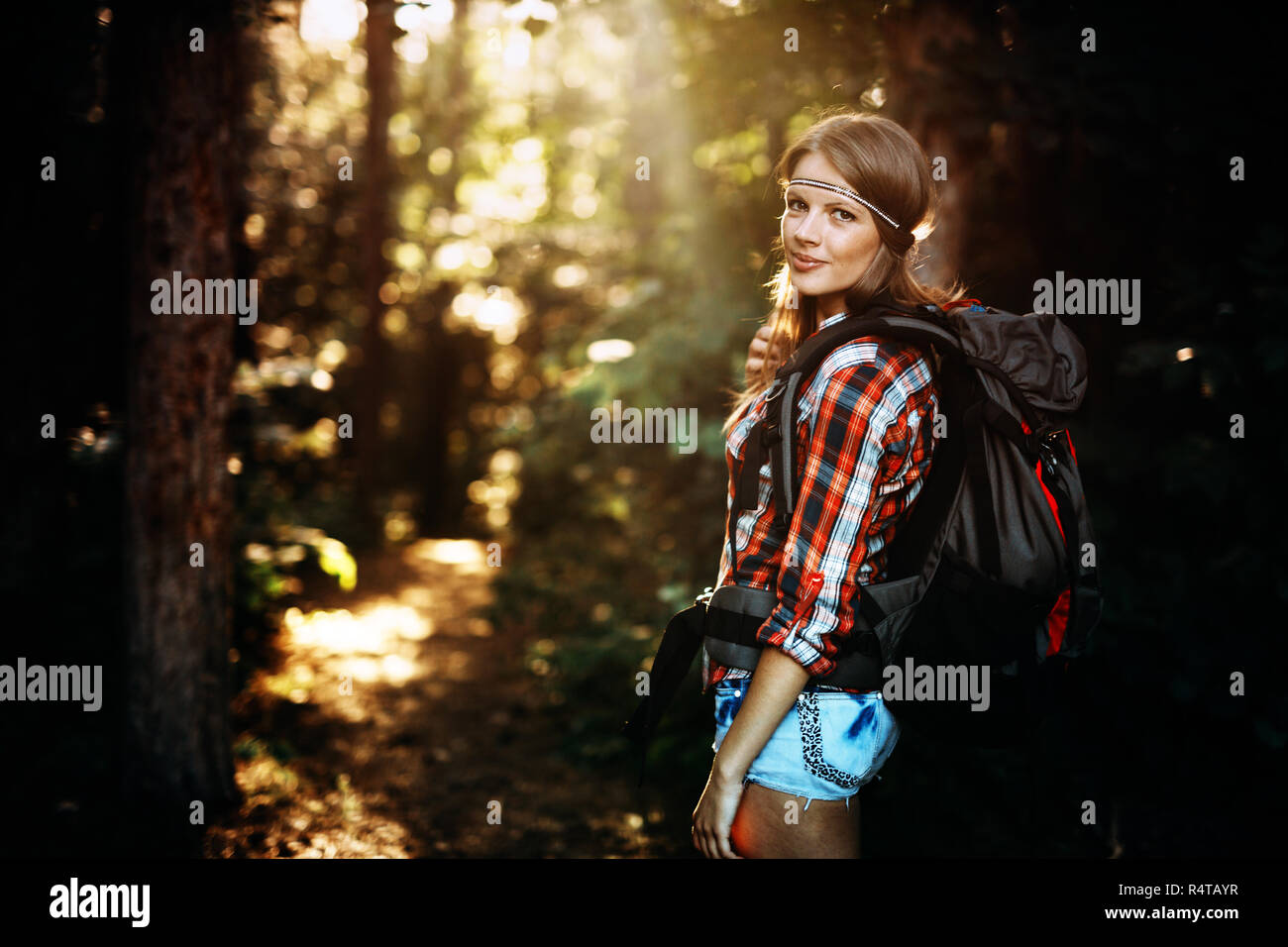 Beautiful and young woman hiking in forest Stock Photo - Alamy