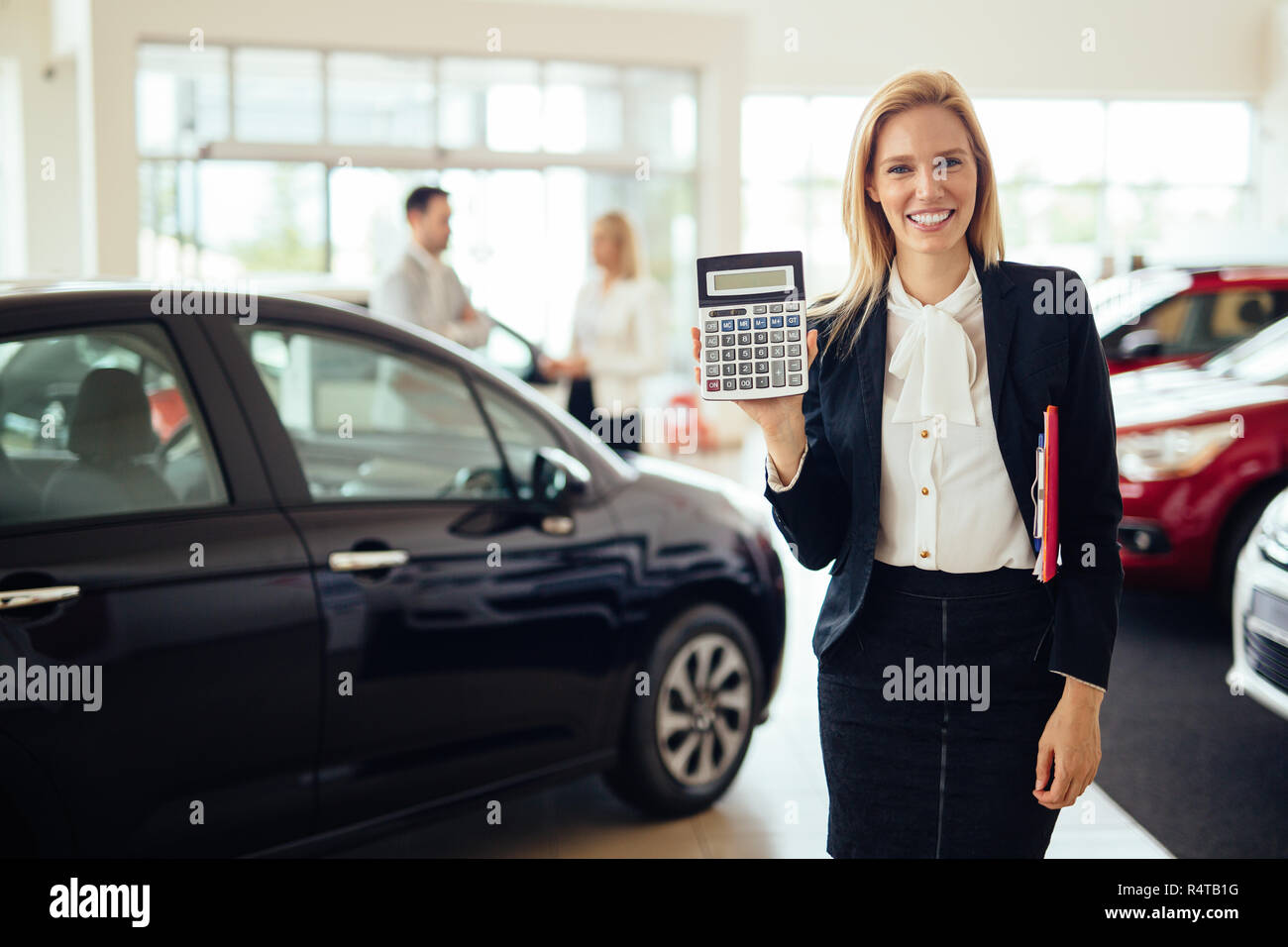 Portrait of young saleswoman in car dealership Stock Photo - Alamy