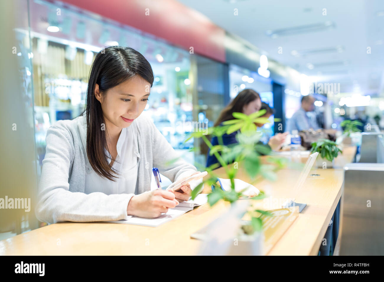 Woman taking note in coffee shop Stock Photo - Alamy