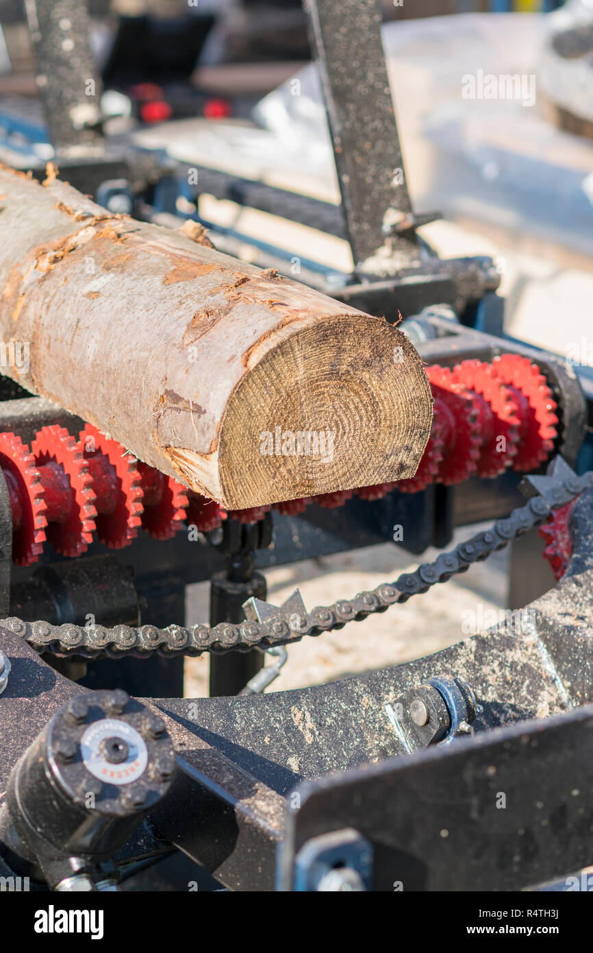woodworking enterprise. Wood Cutting Machine. Partially milled log on a ...