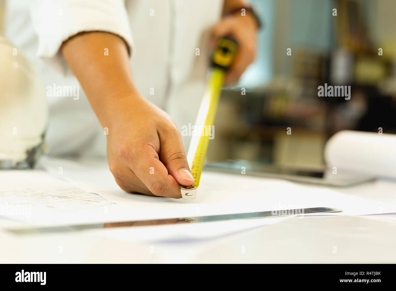 Architecture hand measuring blueprint with tape masure on working table ...