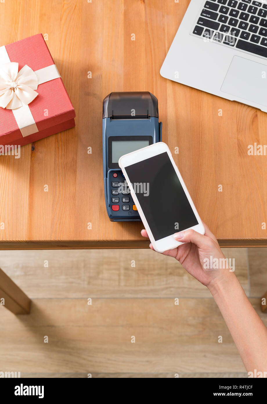 Pay with cellphone on POS machine for present Stock Photo - Alamy