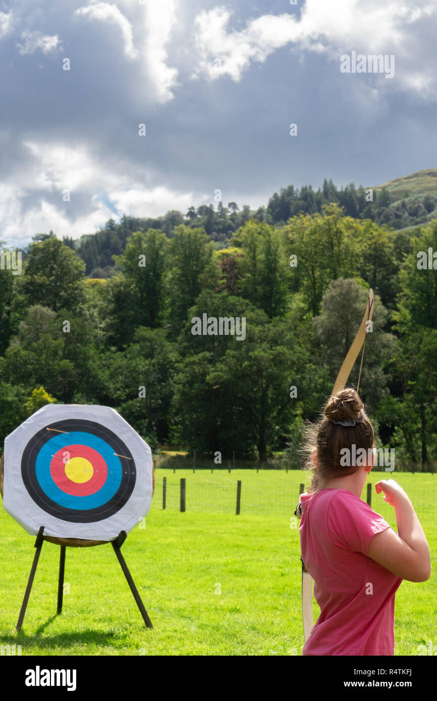 A Girl Aims her Bow and Arrow at an Archery Target in teh Scottish ...