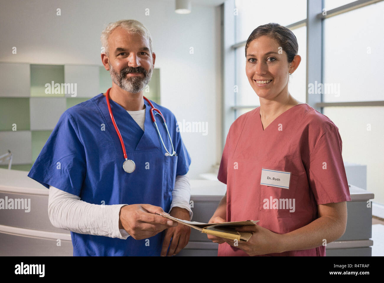 Portrait confident doctors with medical record in hospital Stock Photo ...