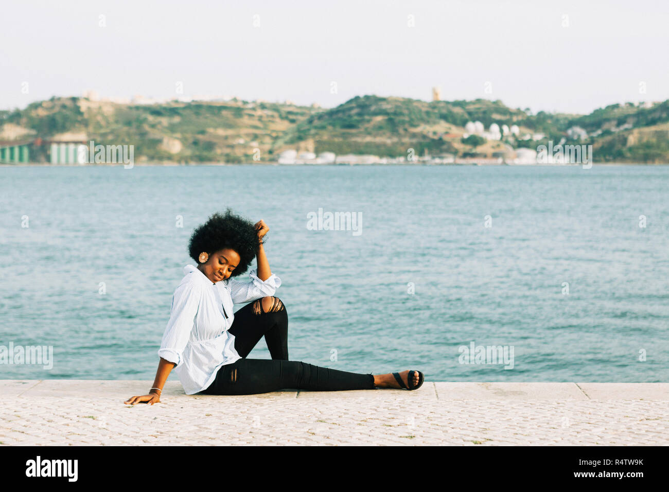 Young woman relaxing at River Tejo waterfront, Belem, Lisbon, Portugal ...
