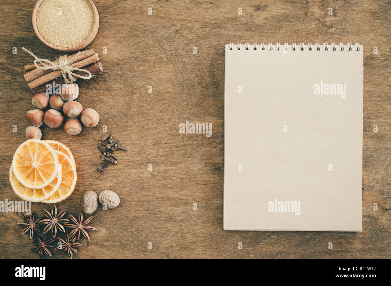 Brown notebook for writing recipe or menu on wooden table. Spices for ...