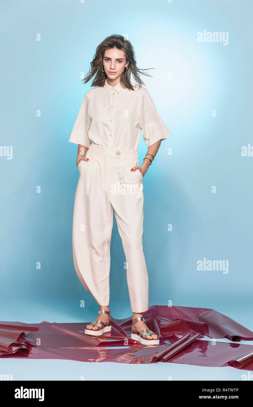 Portrait of female fashion model posing against blue background Stock ...