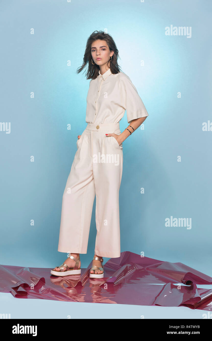 Portrait of female fashion model posing against blue background Stock ...